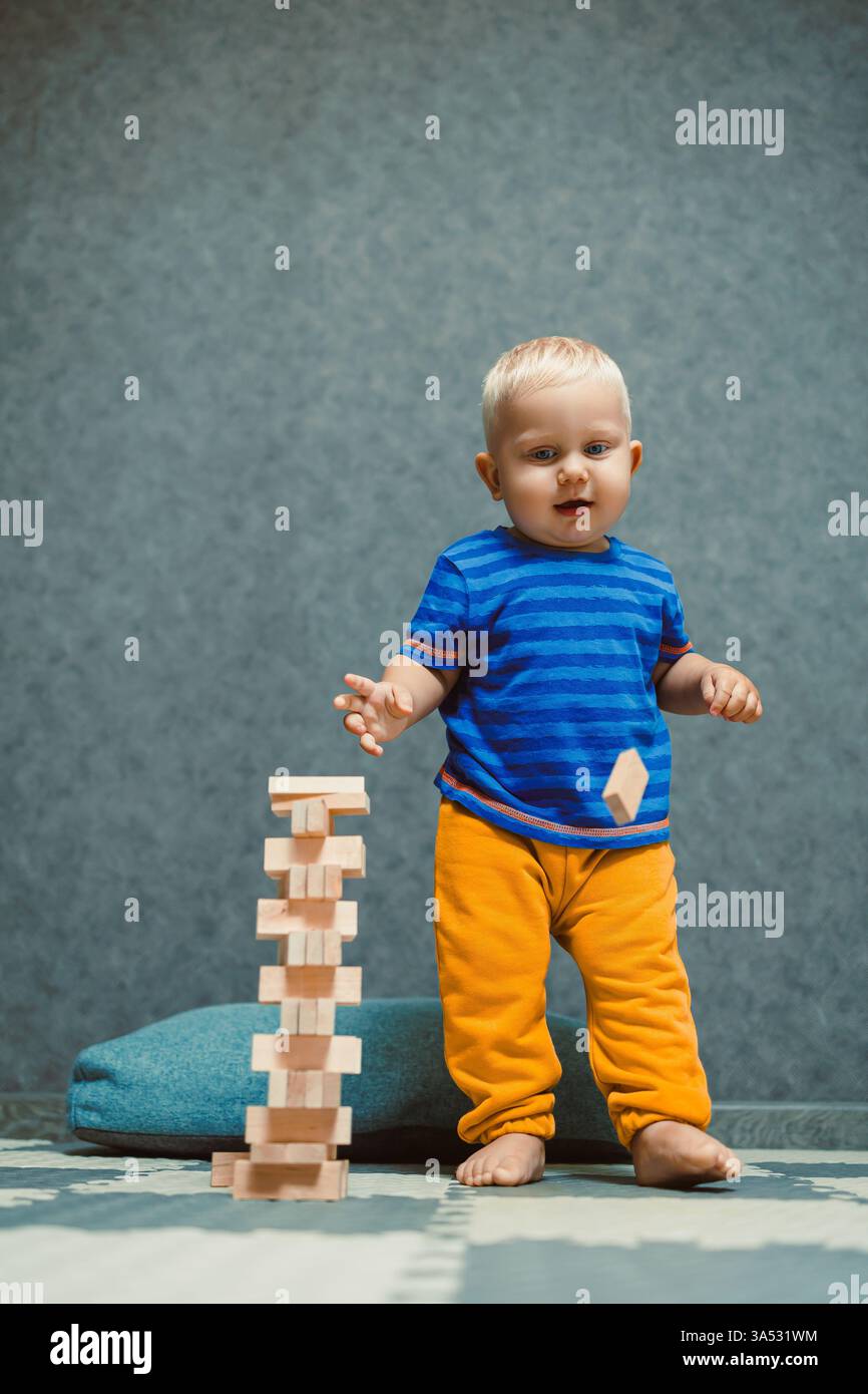 A cheerful and joyful toddler stands proudly next to a colorful and ...
