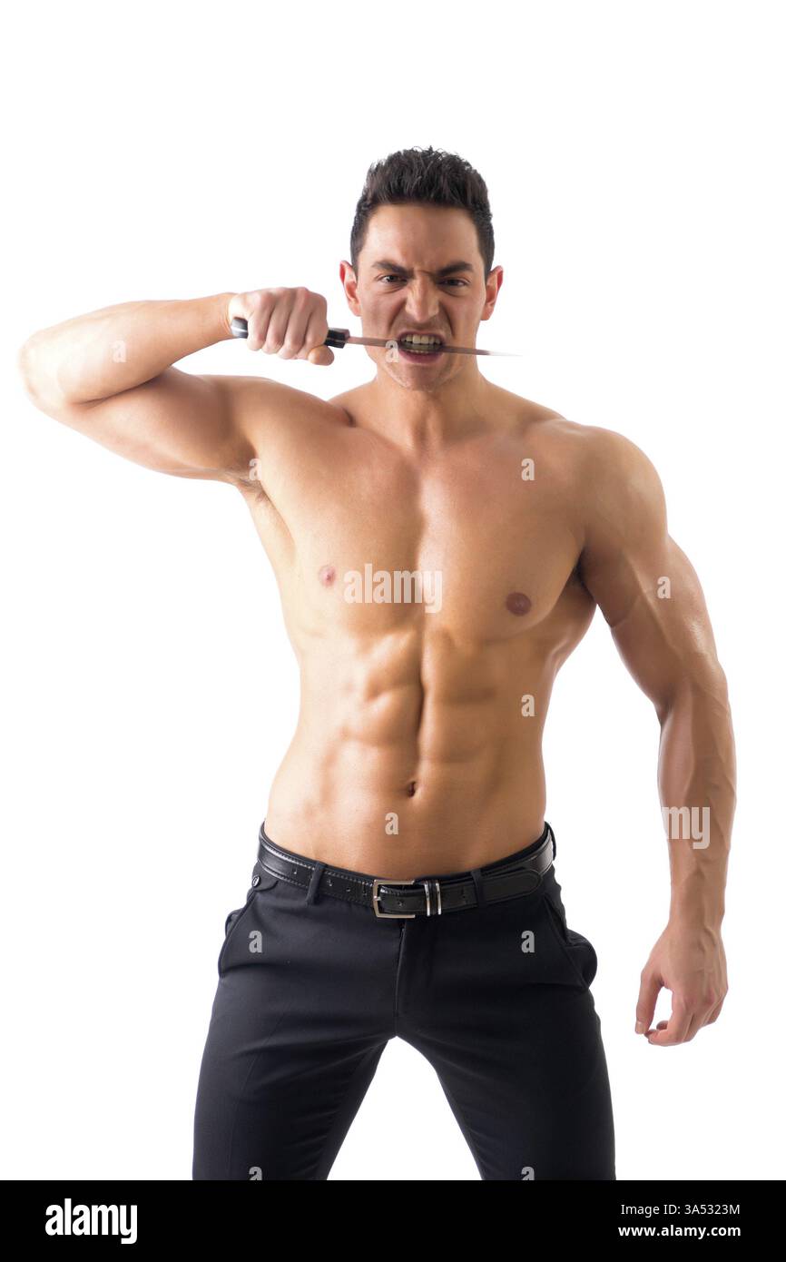 Muscular young man holding big knife biting its blade, isolated on ...
