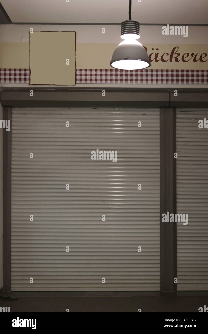 A closed bakery shop with lowered window blinds Stock Photo - Alamy