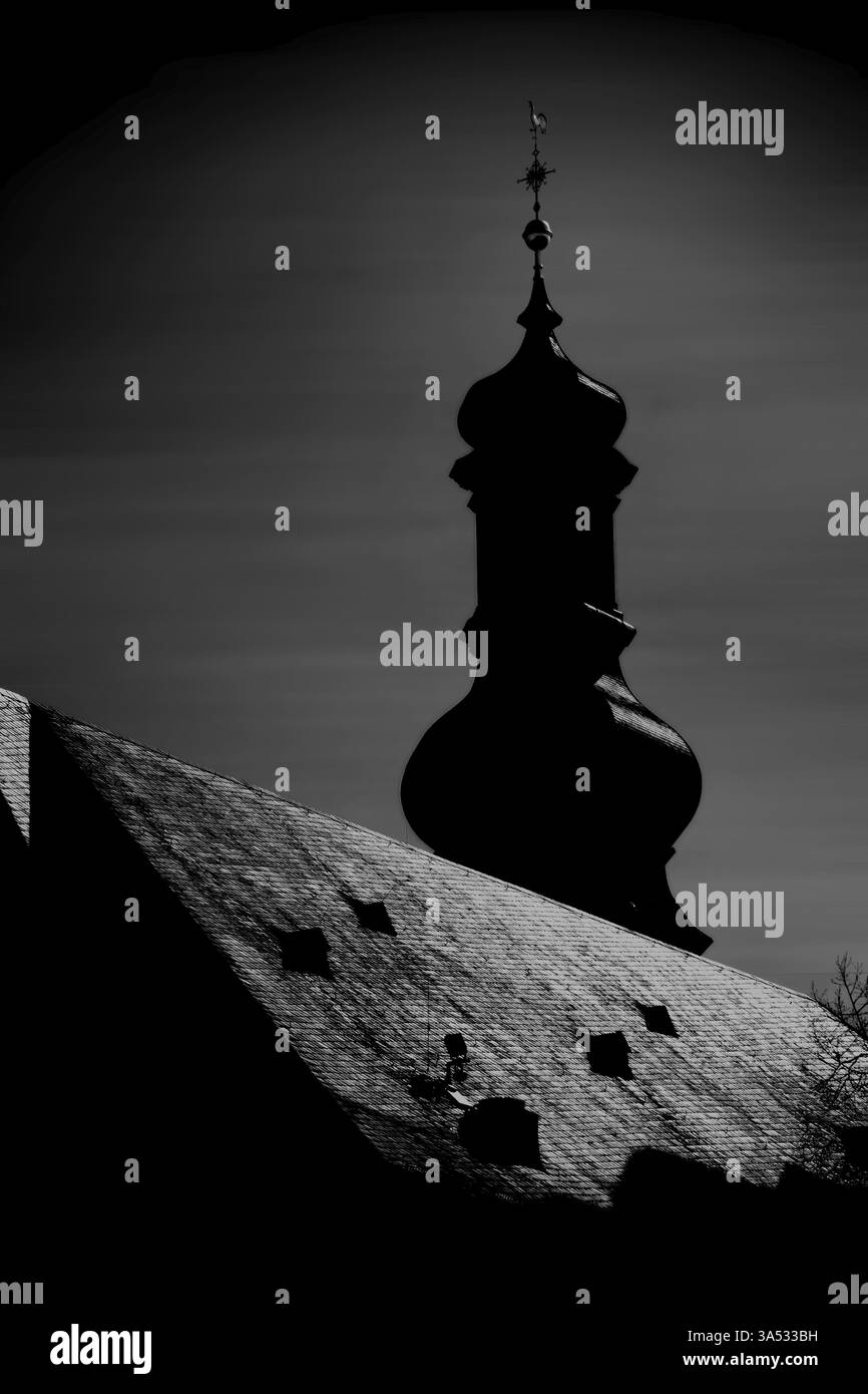 The silhouette of a church tower in the incident moonlight against a ...