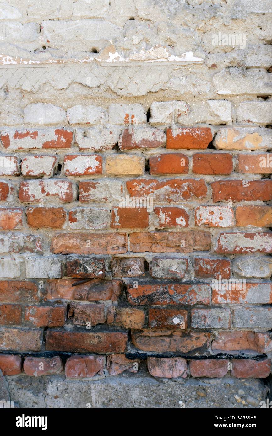 The wall showcases a mixture of red and gray bricks, revealing the age ...
