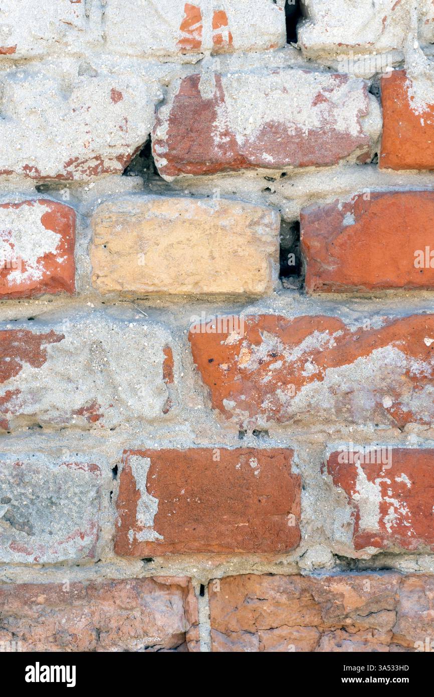 Textured brick wall showcases a variety of red, beige, and gray bricks ...