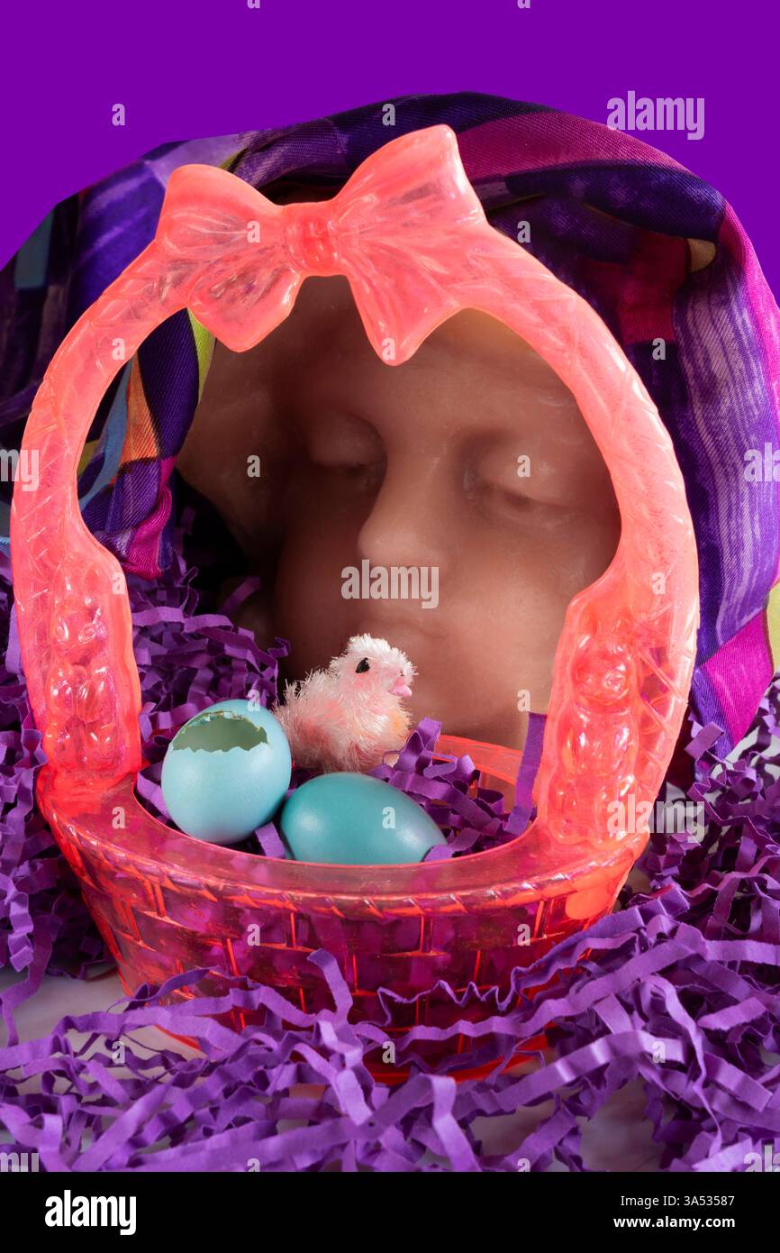 Easter basket with wax child model head looking at new bird hatched ...
