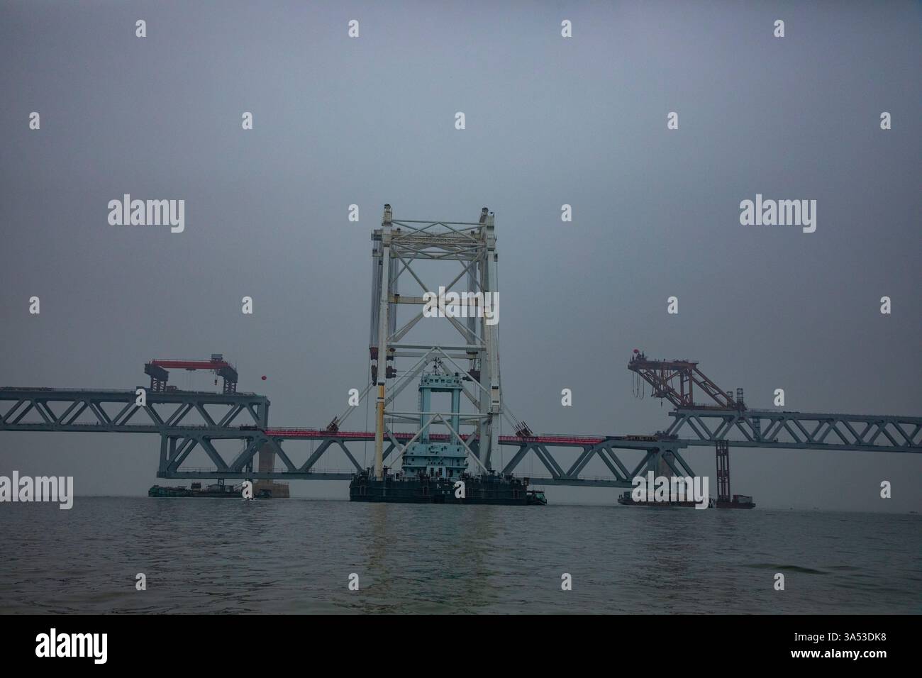 A giant crane transports the final span for installation on pillars 12 ...