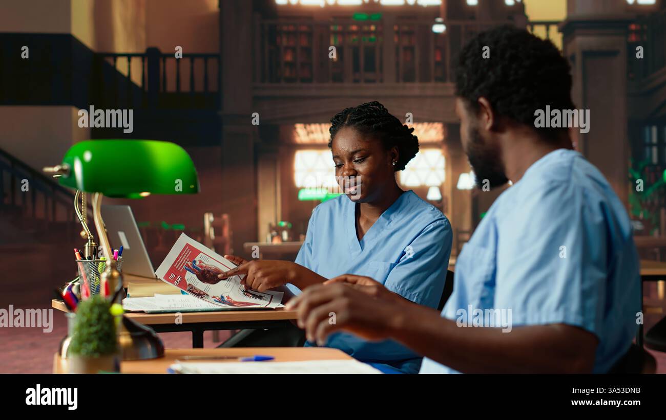 Future nurses studying anatomy class notes in a university library ...