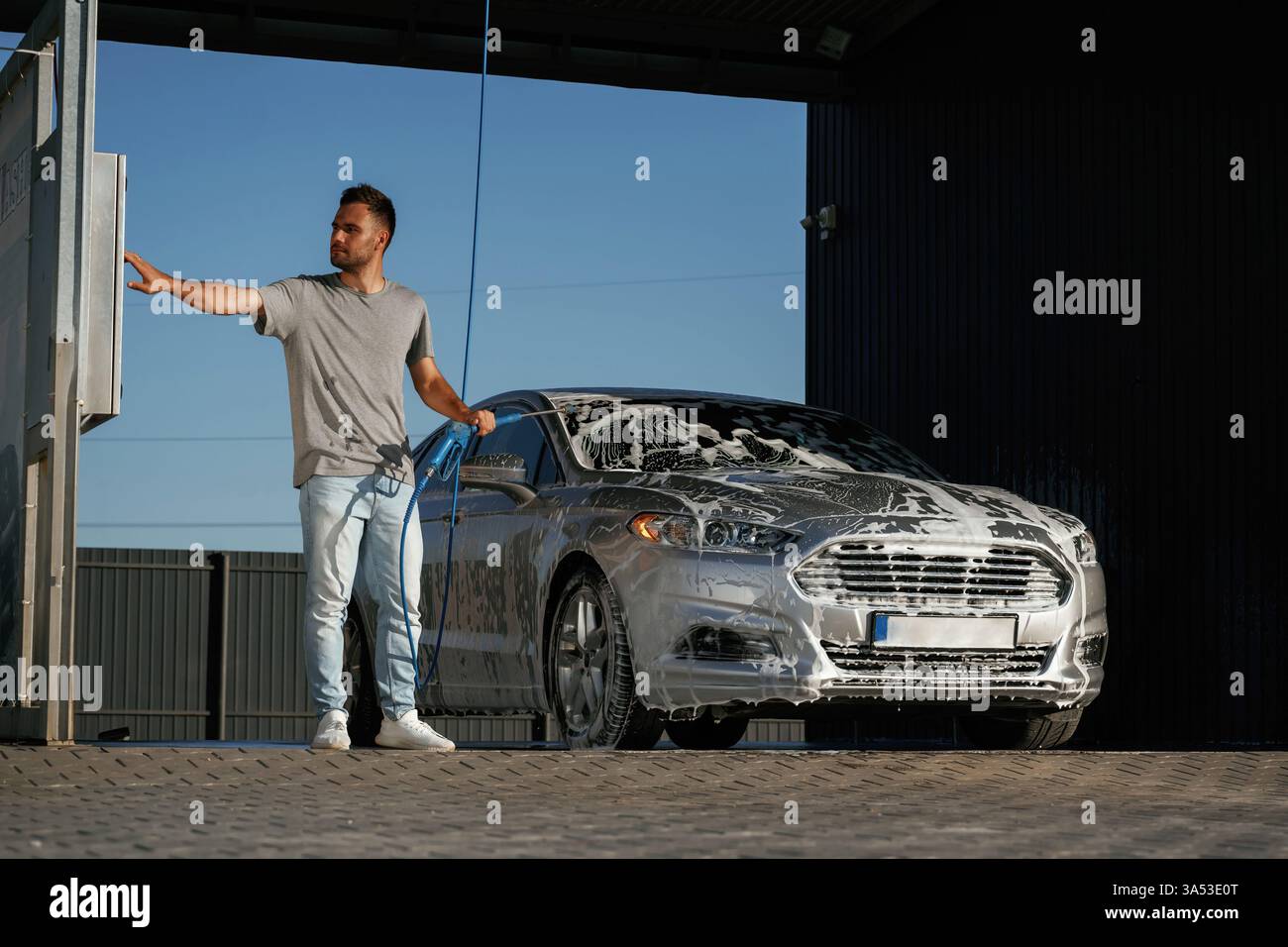 Foam is being washed, automobile is in soap. Man is with his car ...