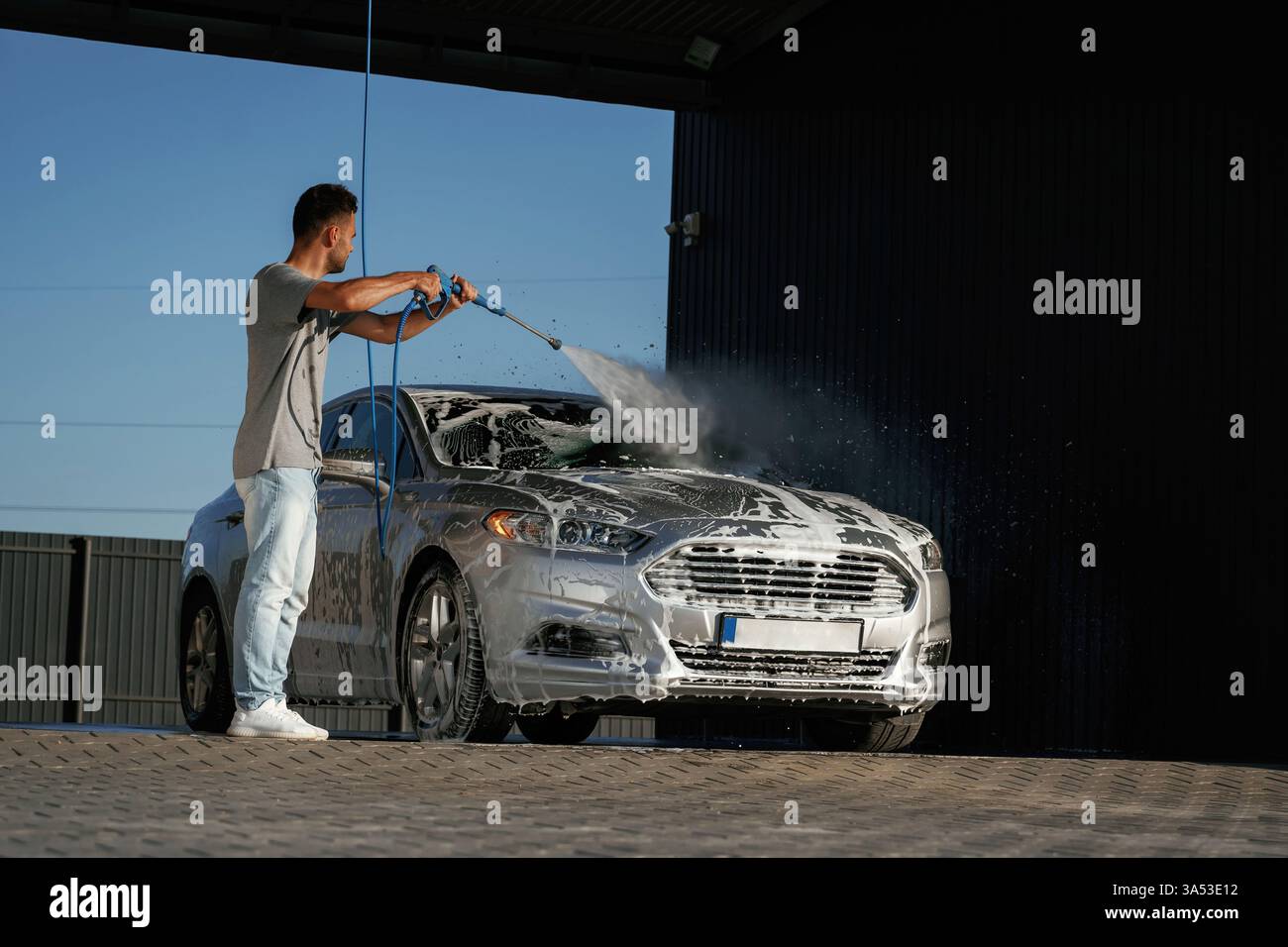 Foam is being washed, automobile is in soap. Man is with his car ...