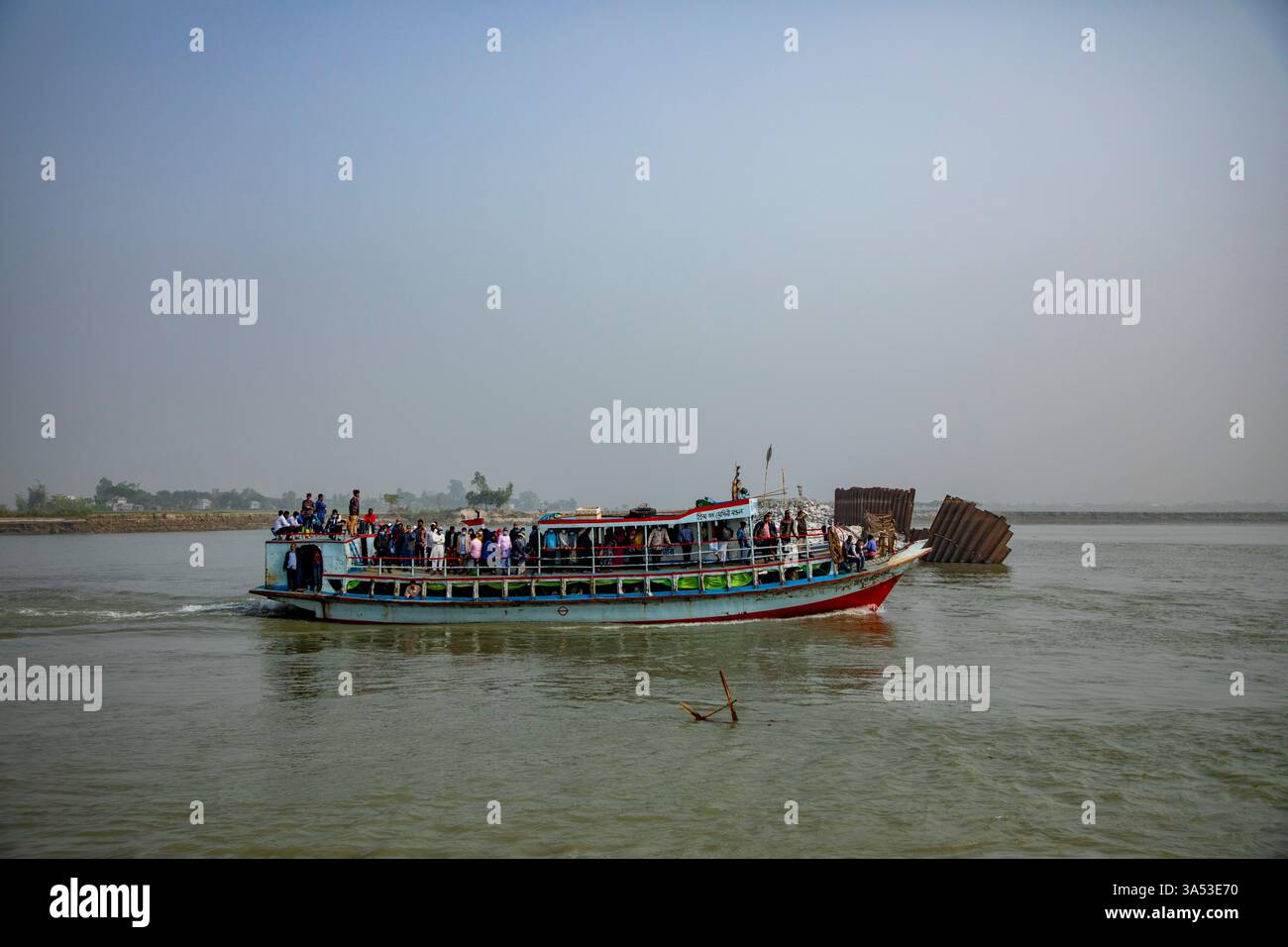 A ferry navigates beneath the Padma Multipurpose Bridge, which spans ...