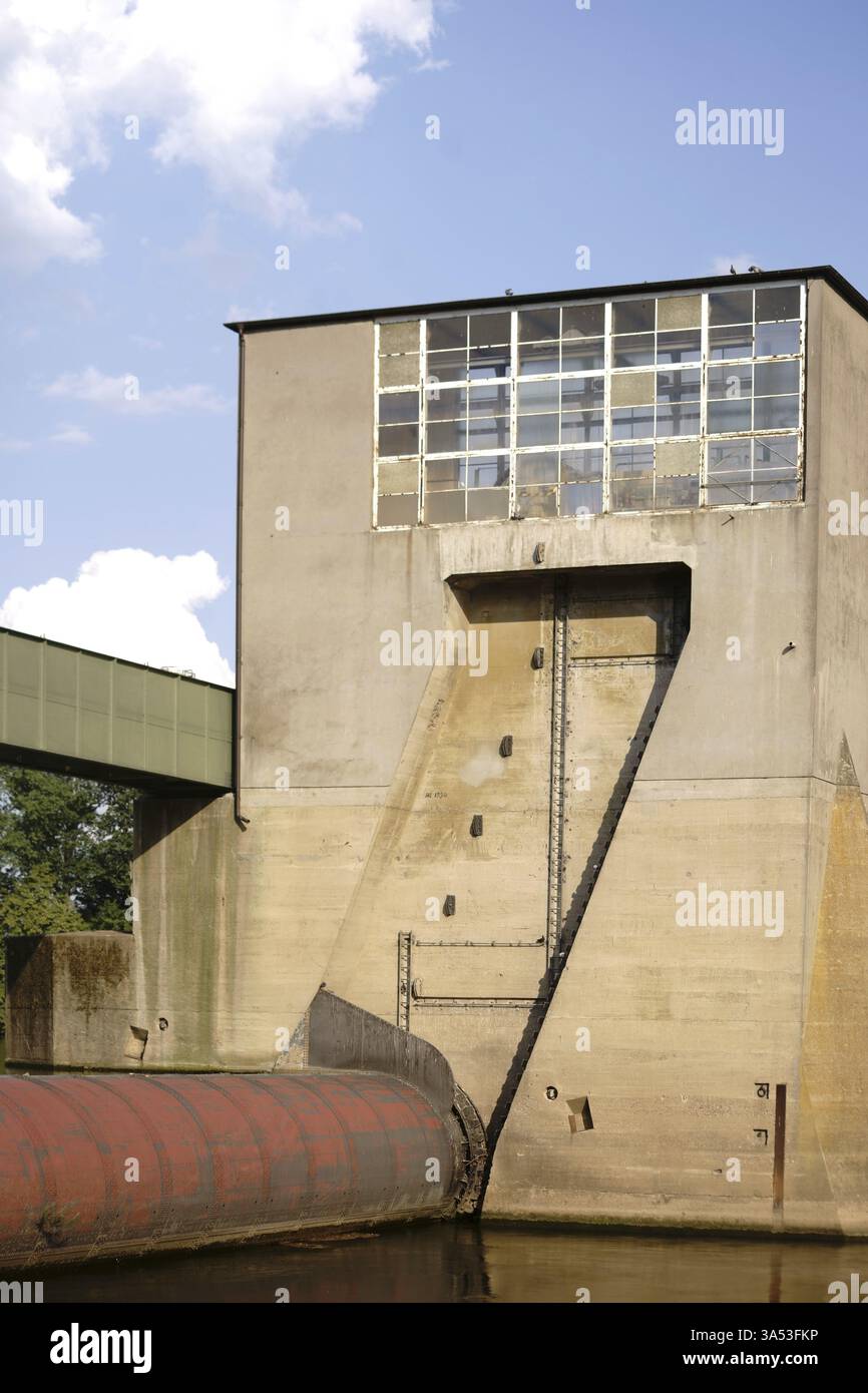A closed river lock with dormant river water and industrial buildings ...