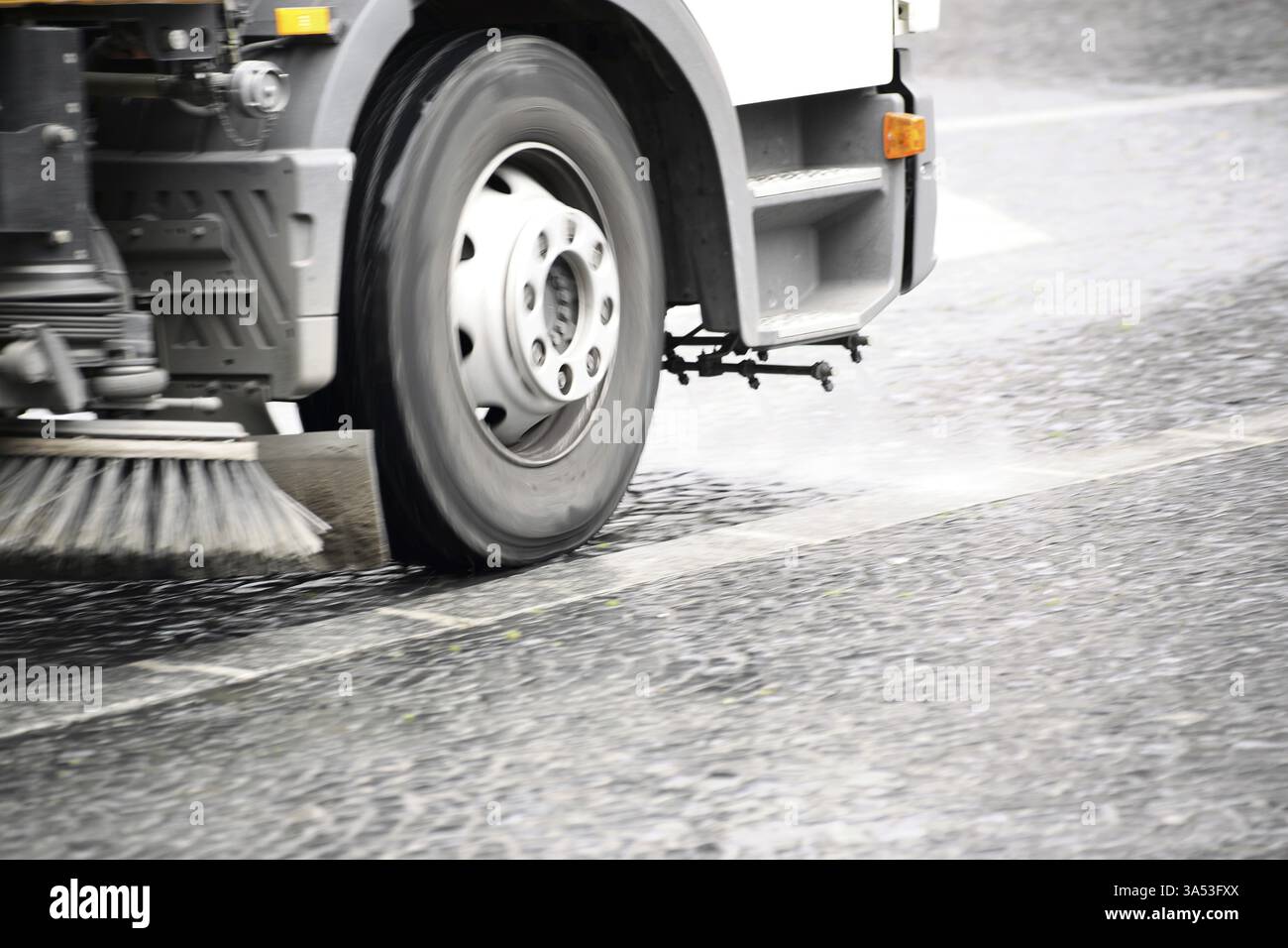 A street cleaning vehicle removes dirt from a pavement with paving ...