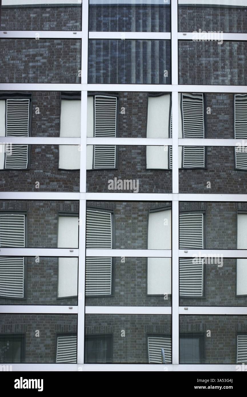 The abstract reflection of windows with shutters in mirrored windows ...
