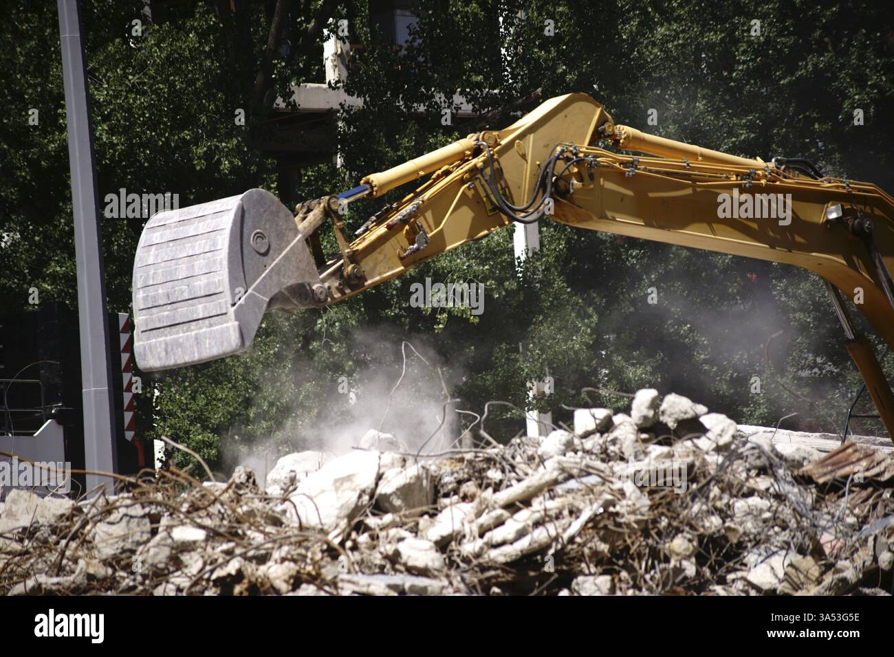 An excavator stands at the construction site of an industrial building ...