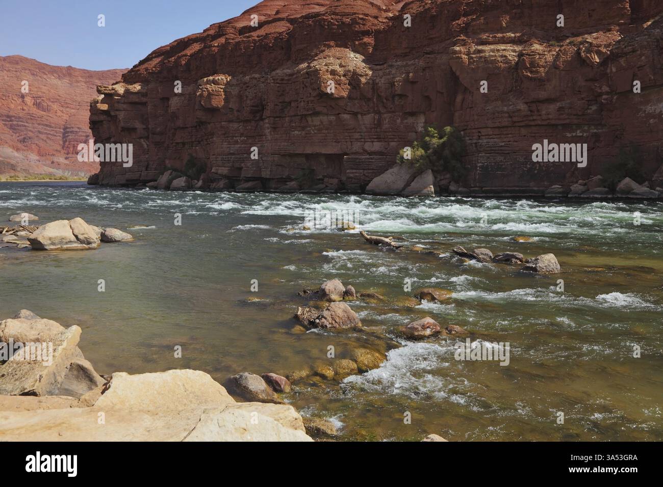 The stones in the shallows of the Colorado River in the red rocks of ...
