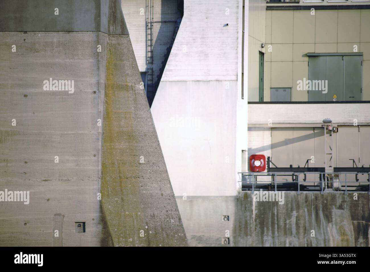 A closed river lock with dormant river water and industrial buildings ...