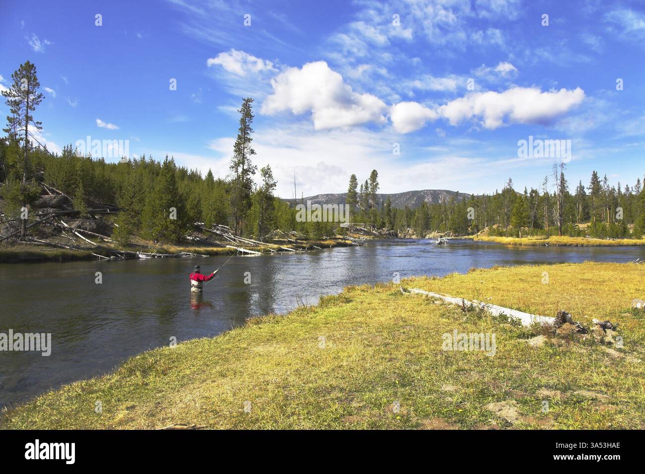 The fisherman in a red jacket with a fishing tackle will fish in the ...