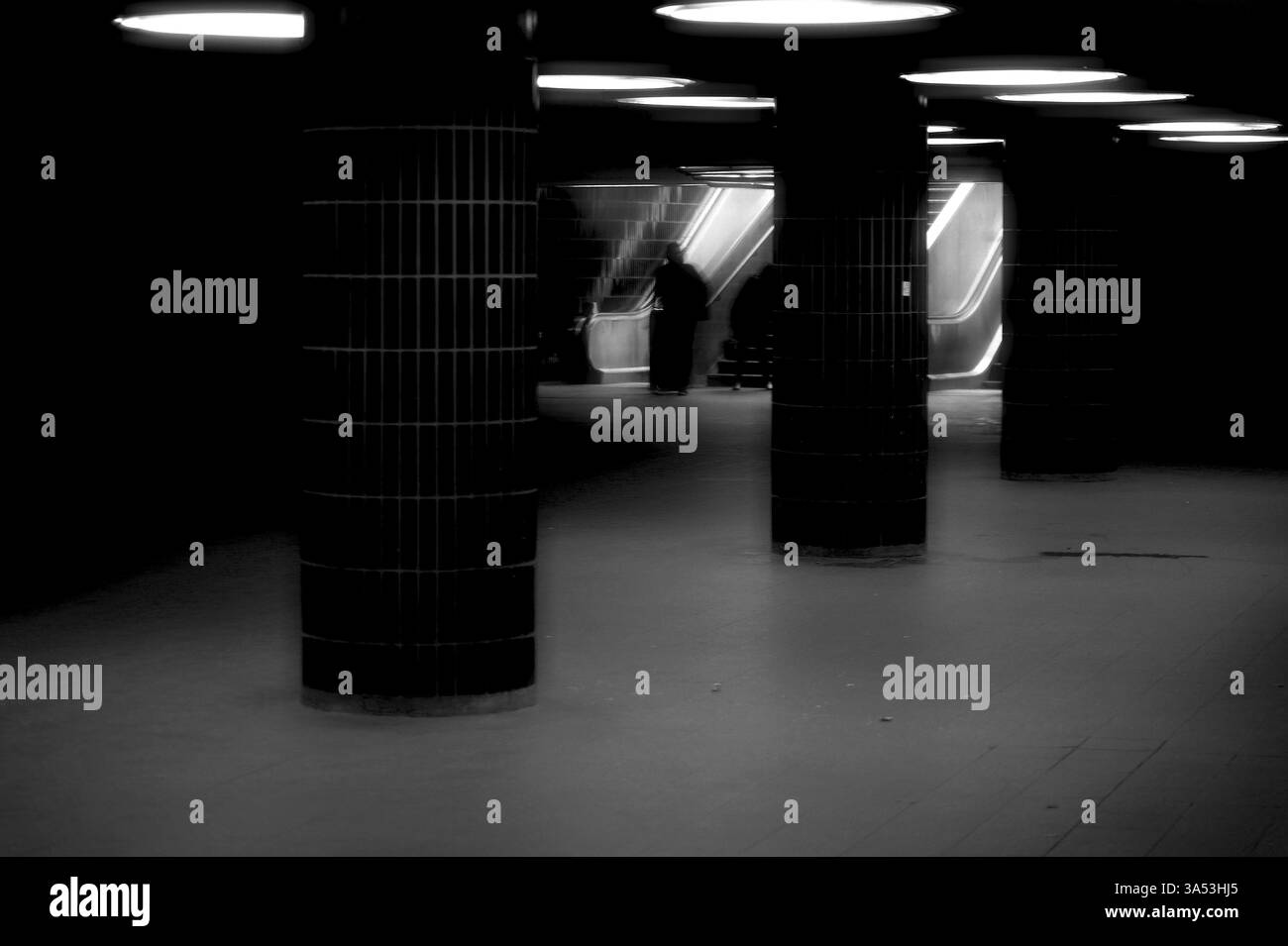 A dark subway with round ceiling lights and an escalator Stock Photo ...