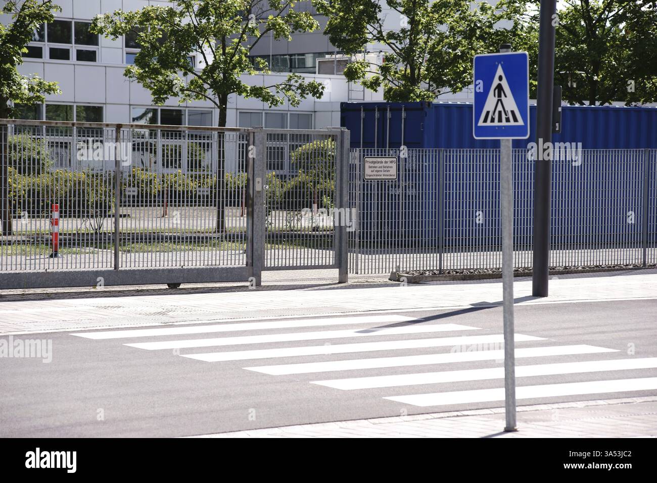 A pedestrian crossing with traffic signs in front of the entrance to a ...