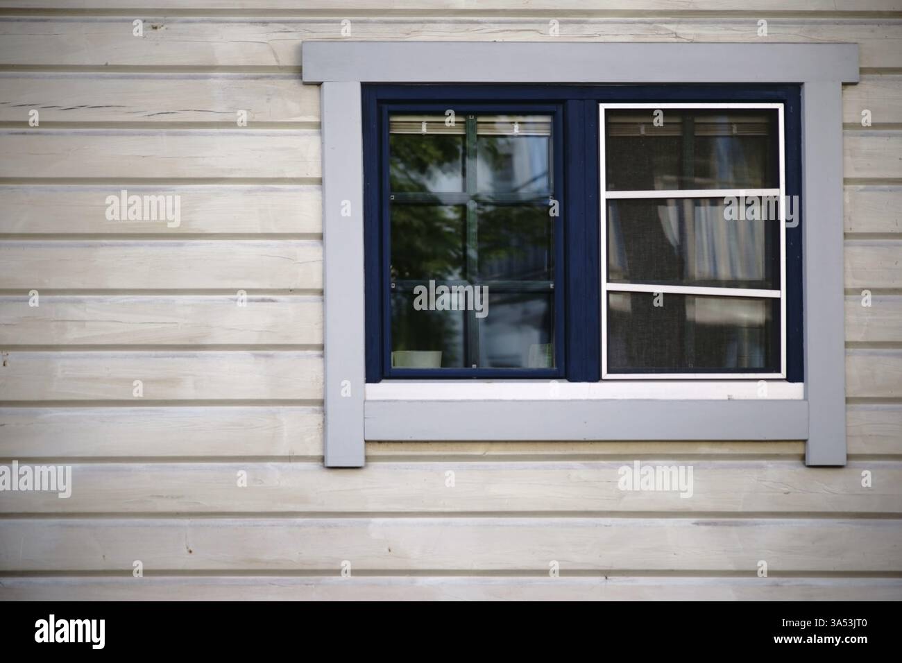 A small window with window crosses in a new wooden hut made of planks ...
