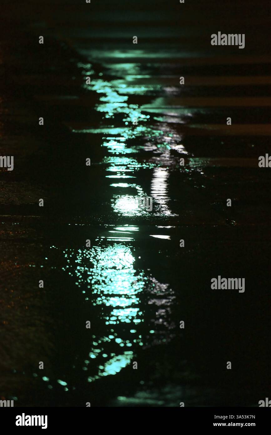 Abstract reflections and colour gradients in a puddle of rain on a ...