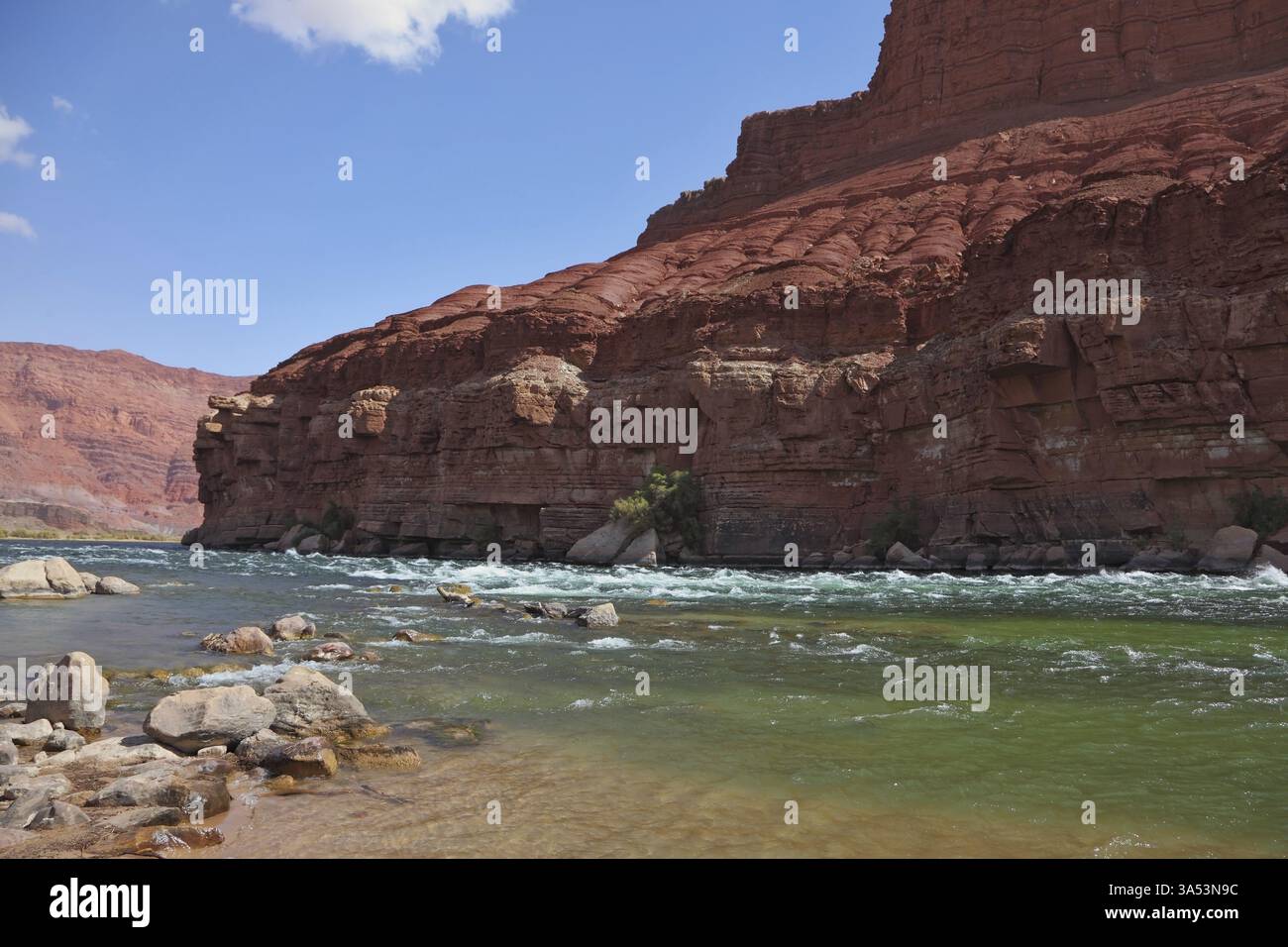 The rapid course of the Colorado River in the red rocks of the desert ...