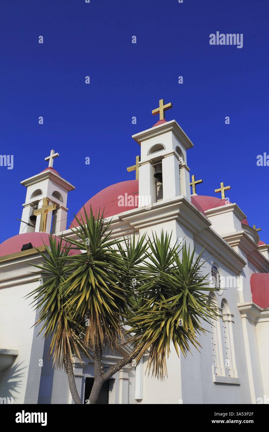 Bright pink dome, whitewashed walls of the holy temple on the shore of ...