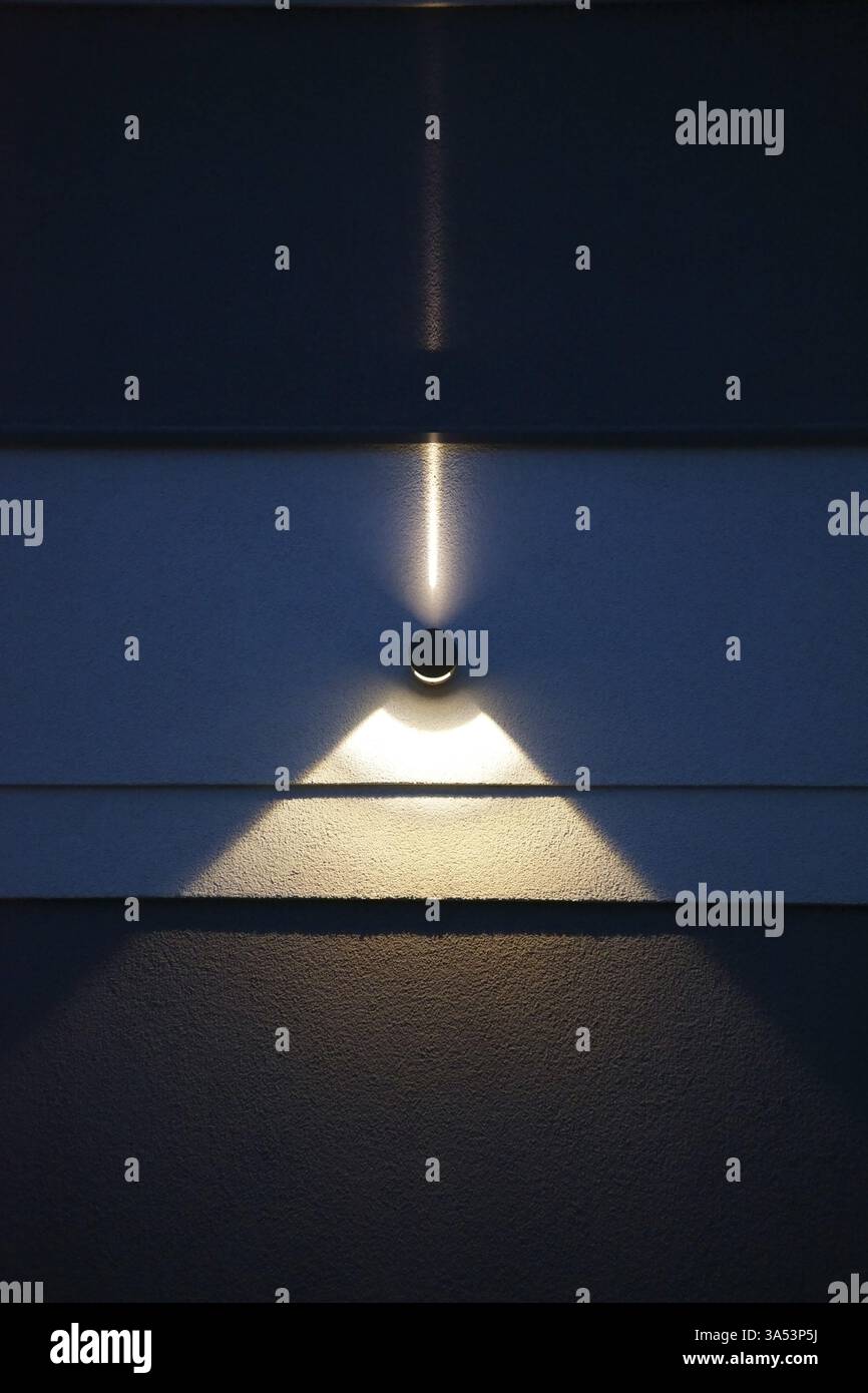Close-up of a wall spotlight on a smooth concrete wall that generates ...