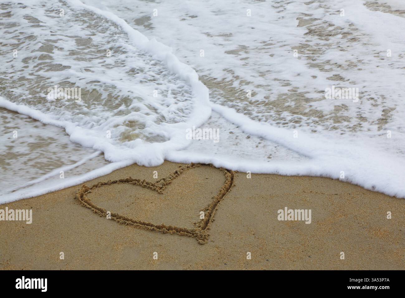 Sandy beach on Koh Samui. In the froth of surf on the sand drawn by ...
