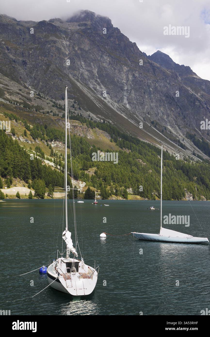 Beautiful mountain Swiss lake. Magnificent sailing yachts are reflected ...