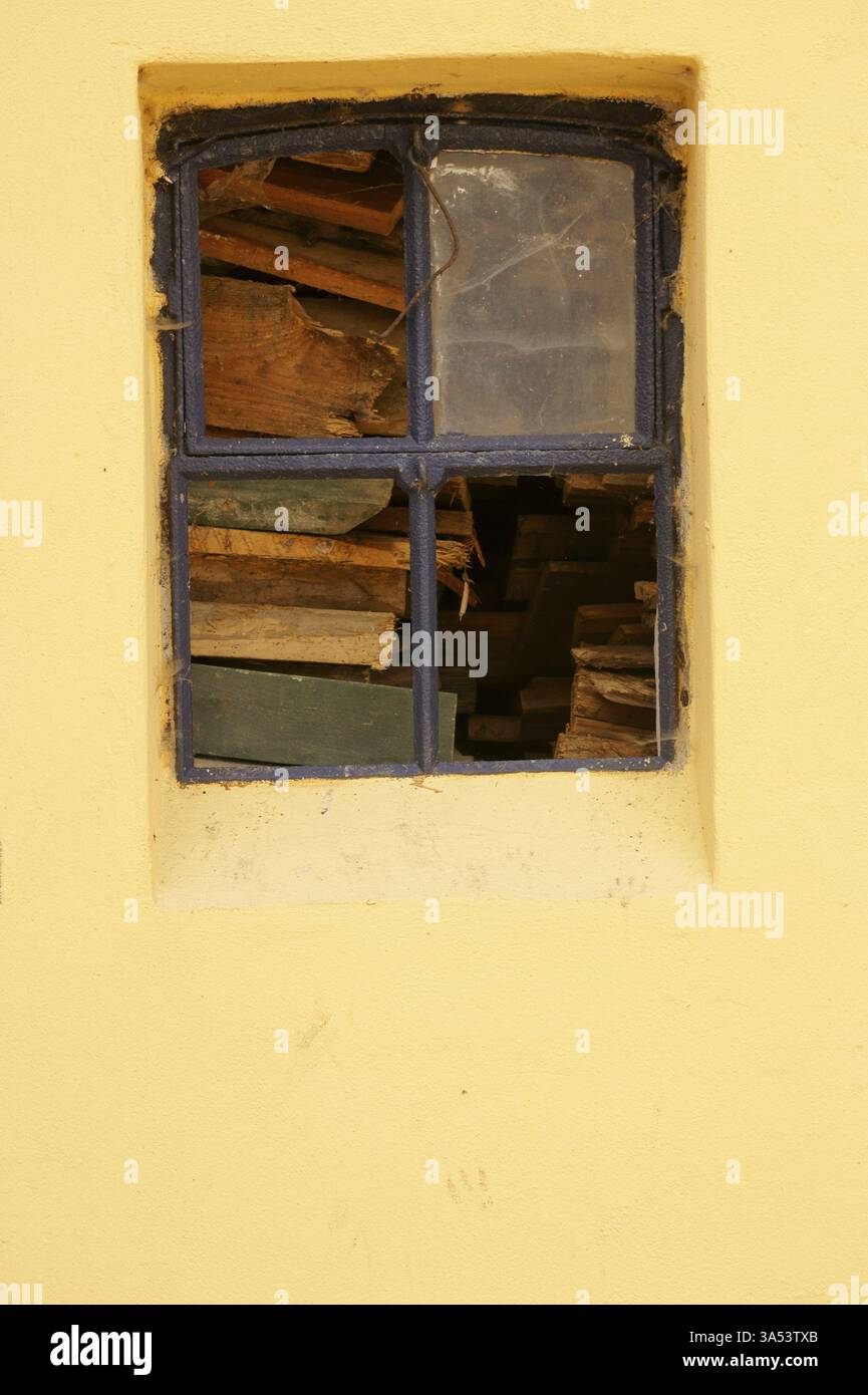 The nostalgic window of a wooden scraper with logs behind the window ...