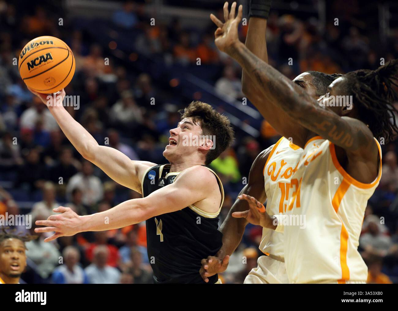 Wofford's Luke Flynn, left, shoots in front of the Tennessee defense ...