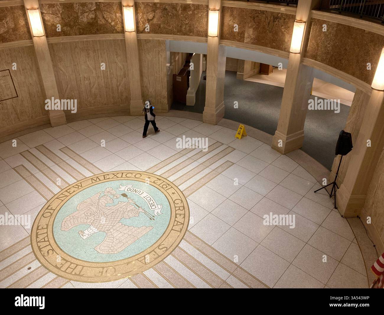 FILE - A pedestrian traverses the rotunda inside the New Mexico Capitol ...