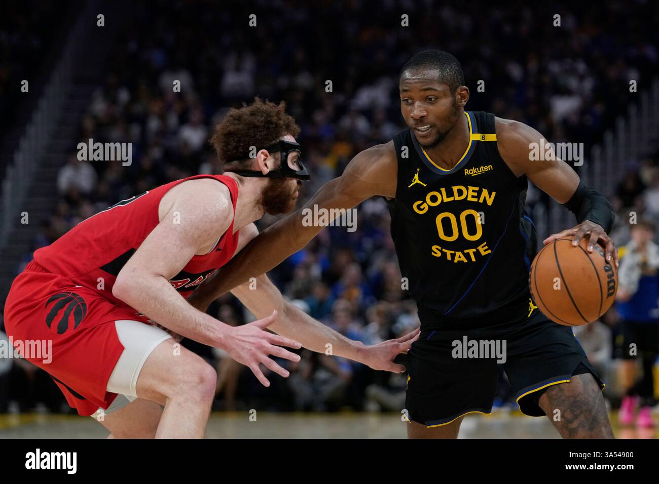 Golden State Warriors forward Jonathan Kuminga, right, moves the ball ...