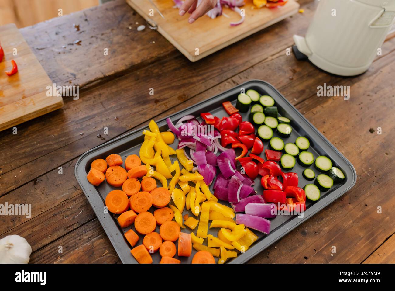 Colorful vegetables on baking tray ready for roasting in cozy kitchen ...