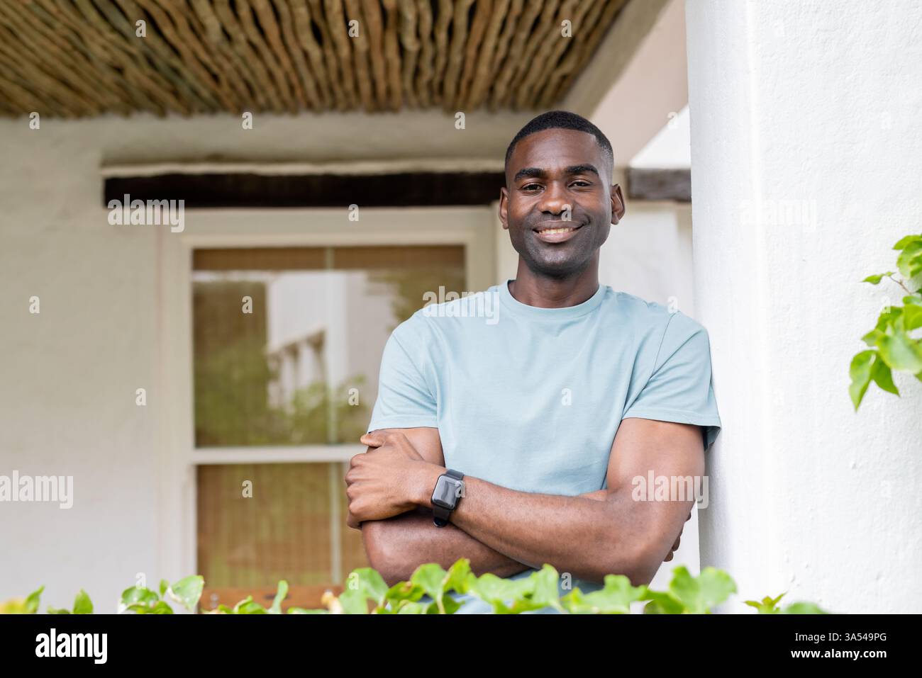Smiling African American man relaxing on vacation, leaning against ...