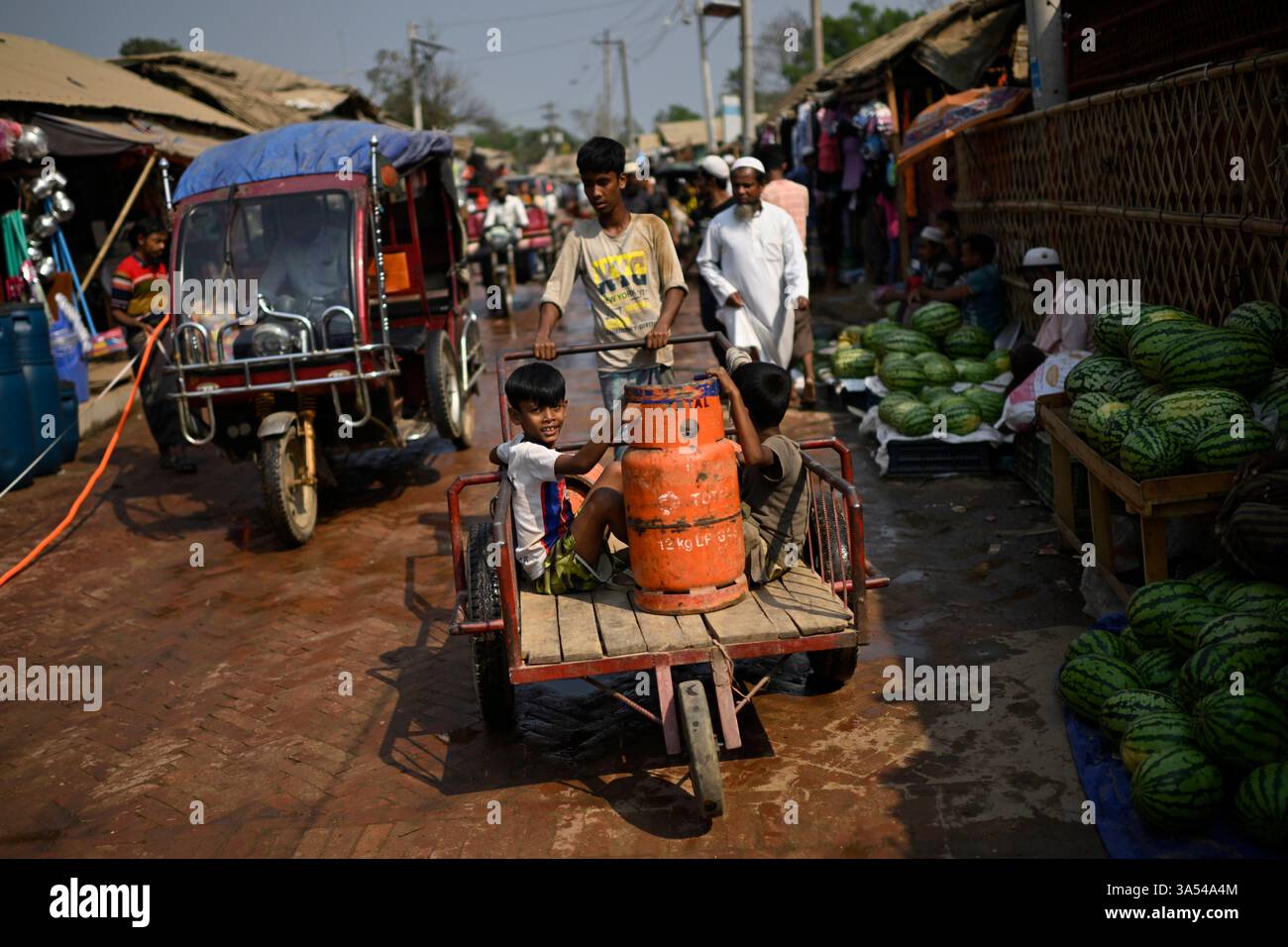 A Rohingya refugee transports a gas cylinder on a hand cart inside ...