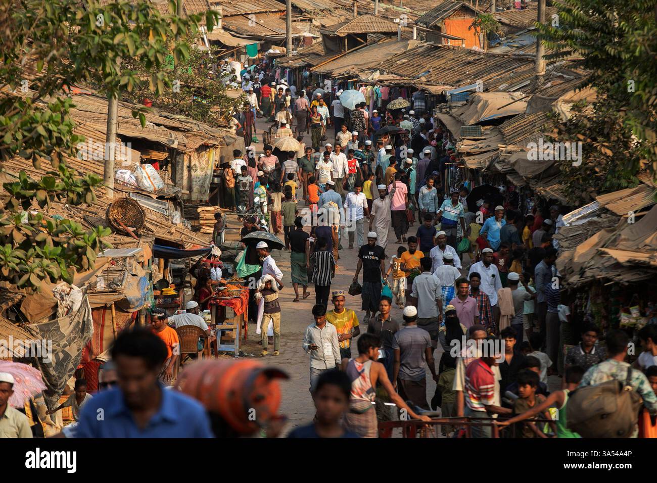 Rohingya refugees walk through a market inside a refugee camp in Cox's ...