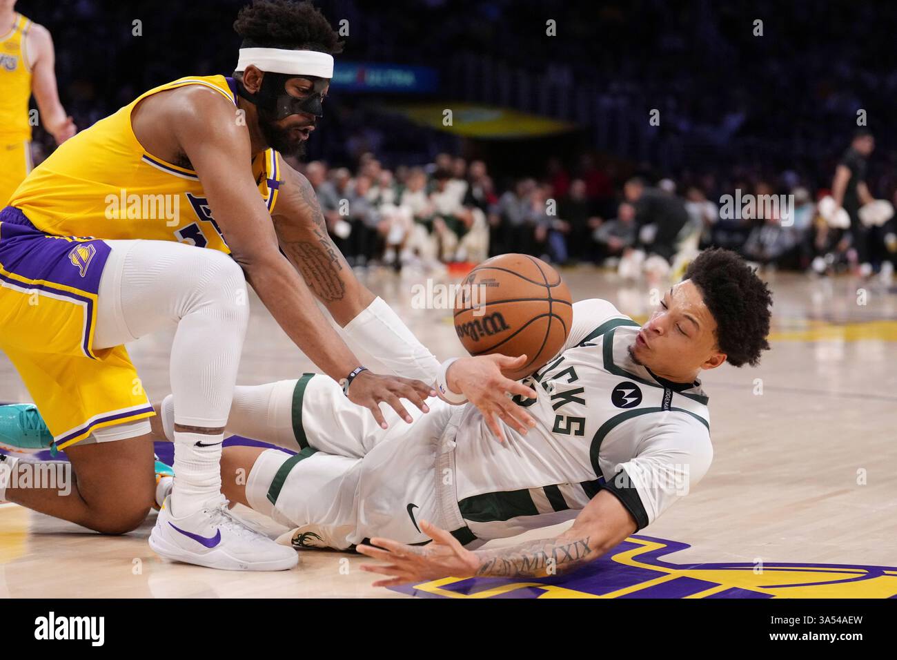 Milwaukee Bucks guard Ryan Rollins, right, and Los Angeles Lakers guard ...