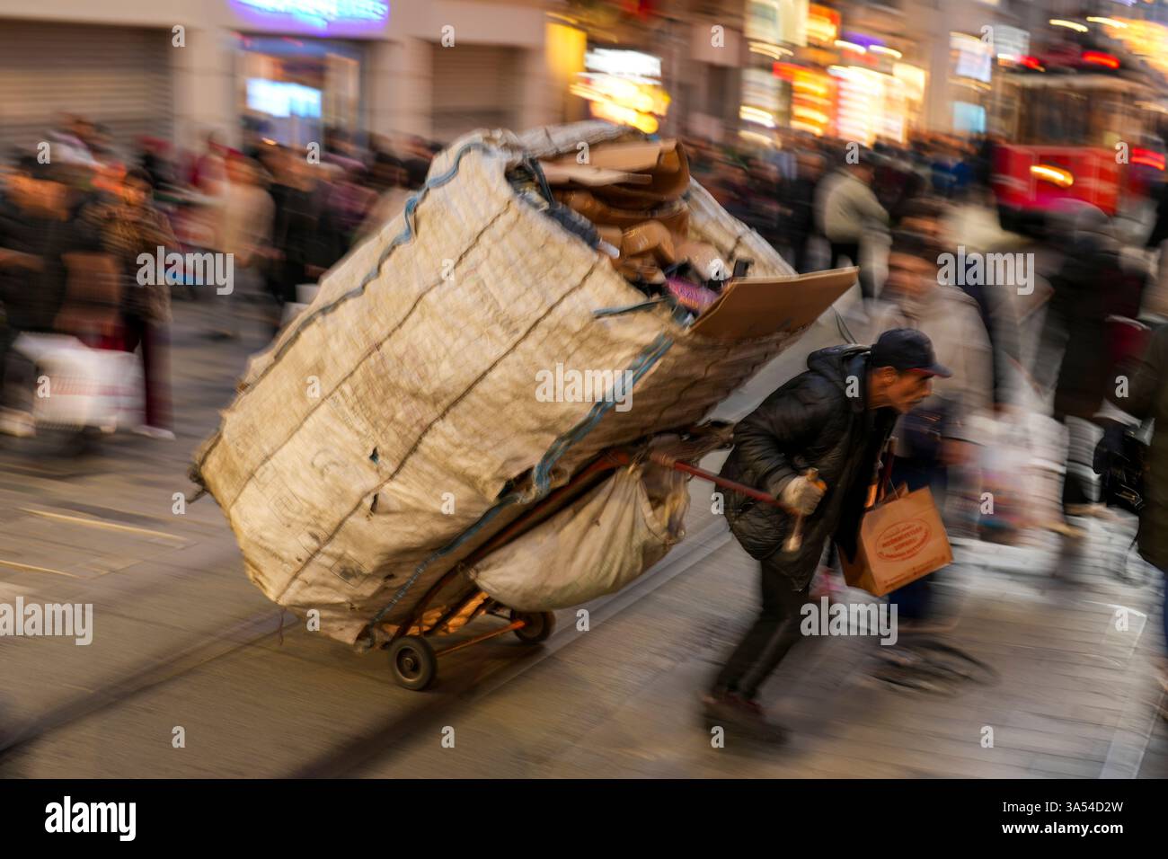 A man pulls his cart with plastic bottles and discarded cartons at main ...