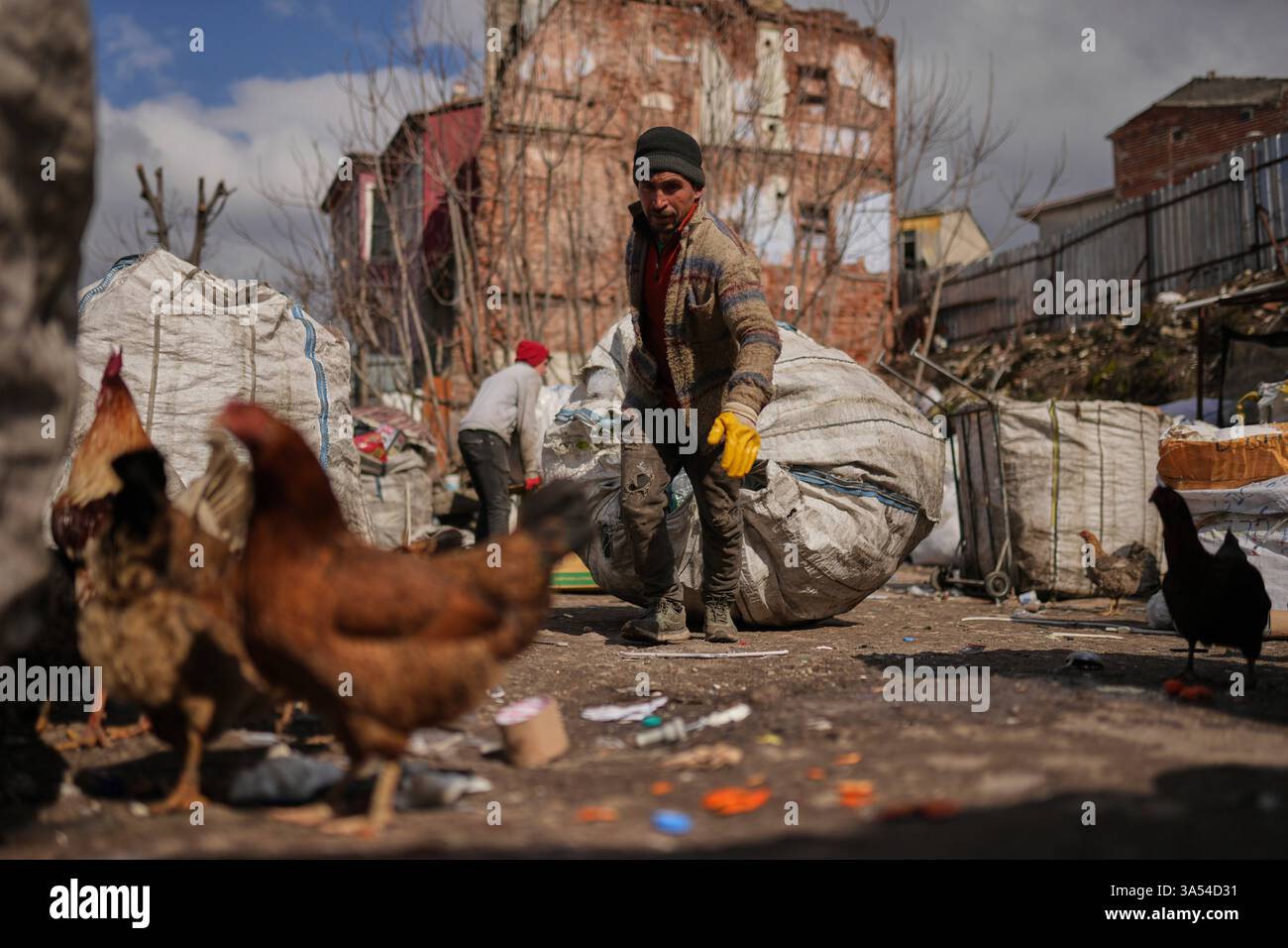 A man pulls a sack full of discarded cartons and plastic items to be ...