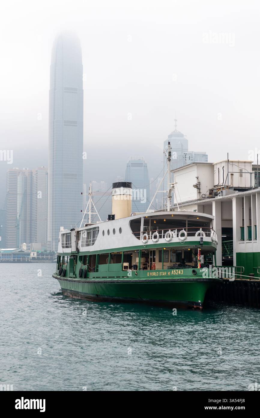 Hong Kong. China- 02.21.2025. A Star Ferry boat docked at its Tsim Sha Tsui Pier with a view of ...