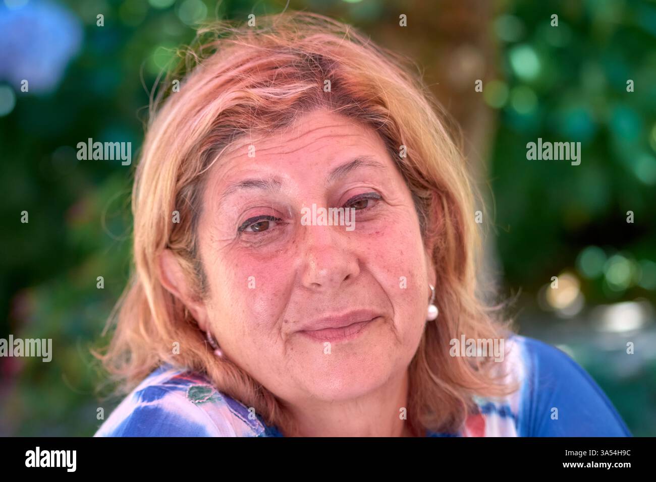 A close-up portrait of a mature woman with a calm and thoughtful ...
