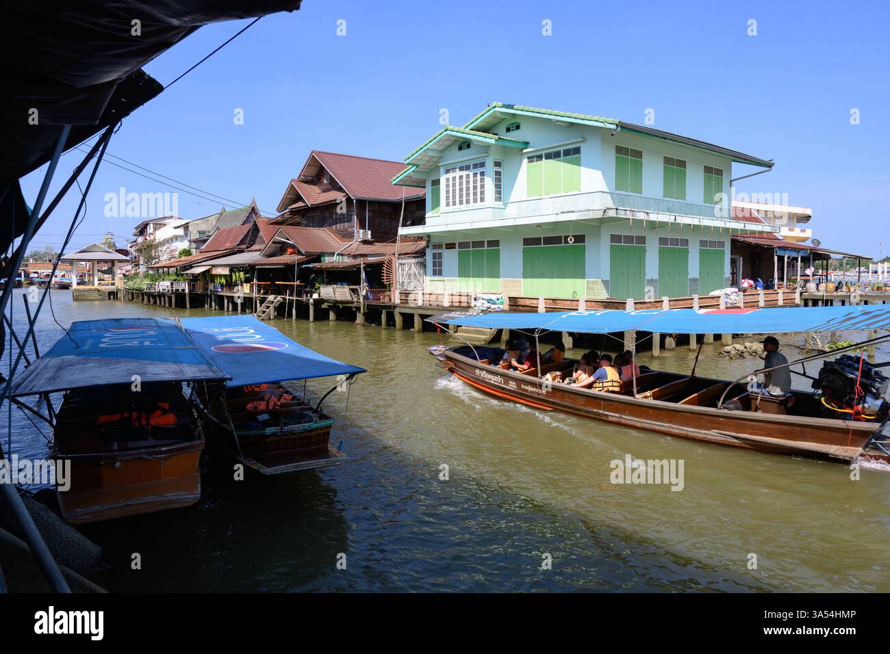 Amphawa, Thailand. March 15th 2025. A tourist boat passes traditional ...