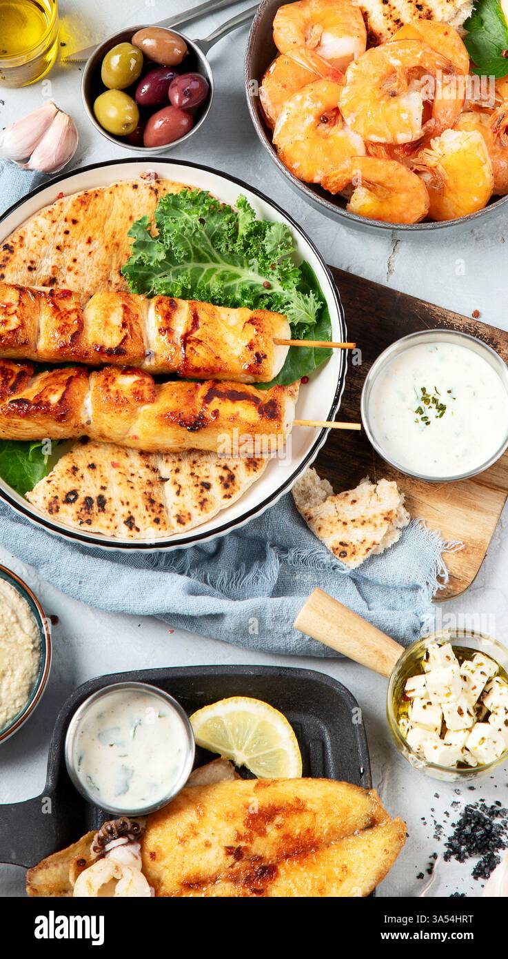 Greek food background. Meze, gyros, souvlaki, fish, pita, greek salad ...