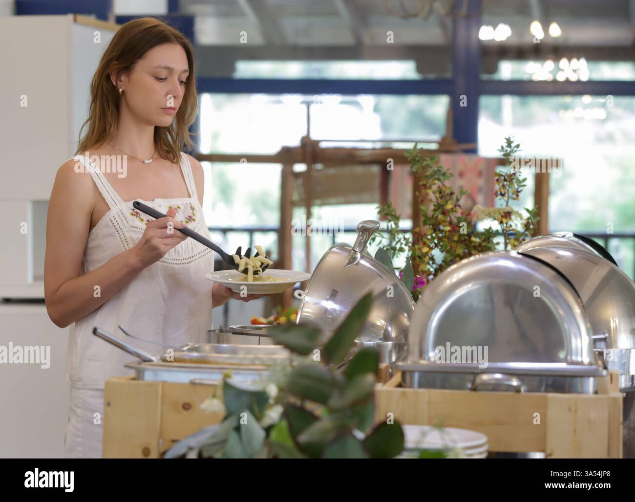 Woman taking food from a buffet line Stock Photo - Alamy