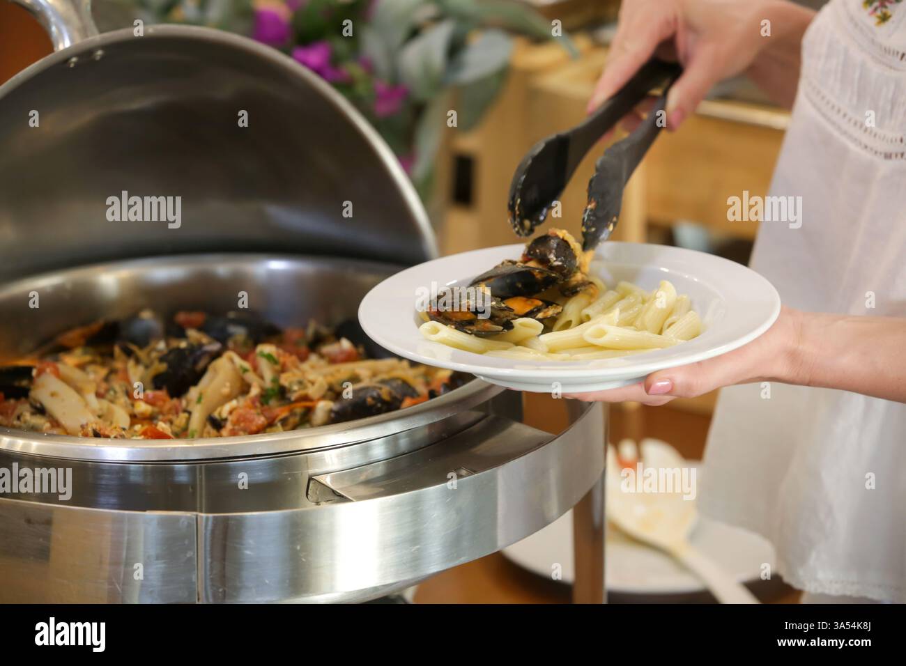 Woman taking food from a buffet line Stock Photo - Alamy