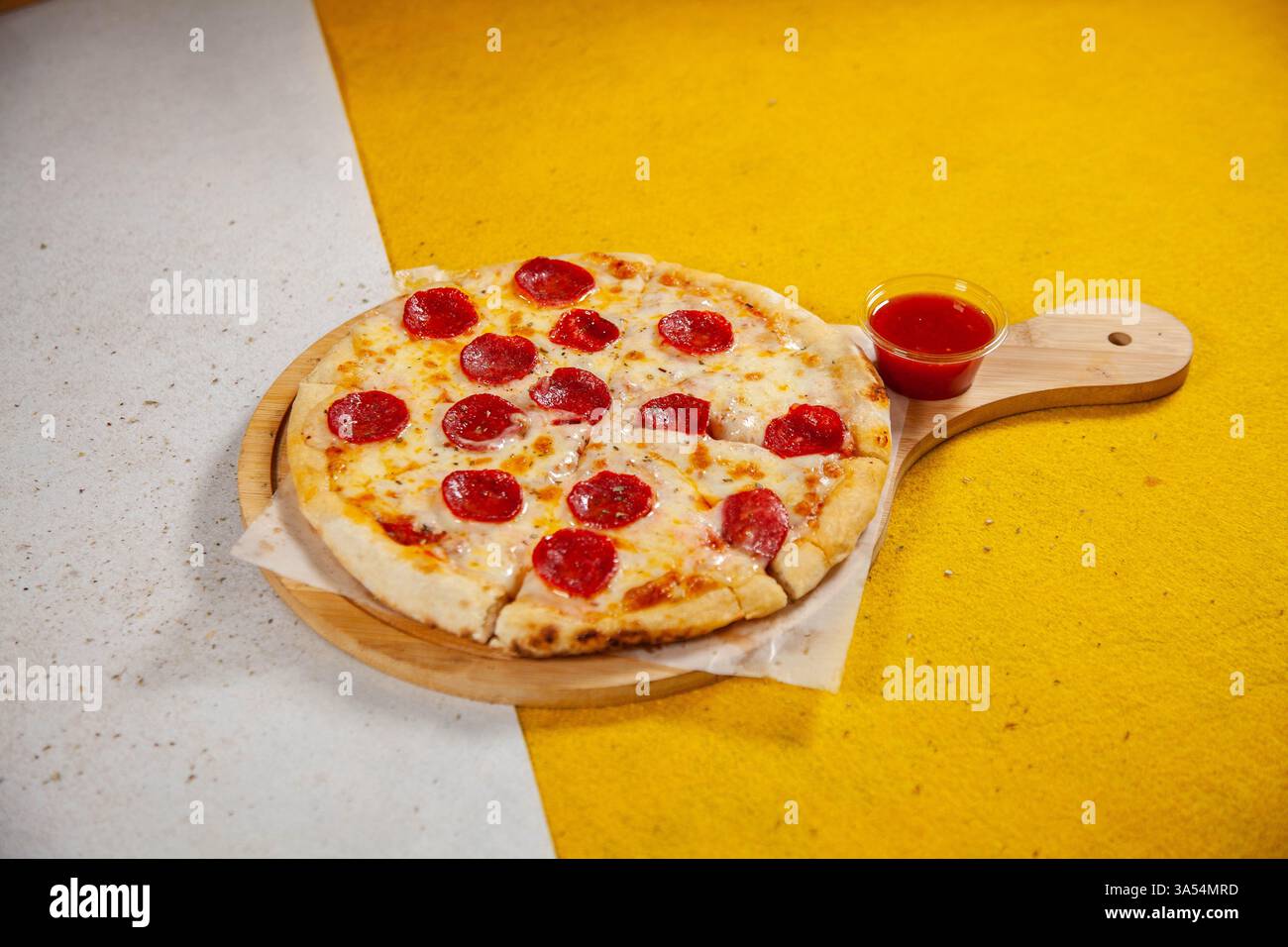 Napolean style wood fired flat bread pepperoni pizza on a white and ...