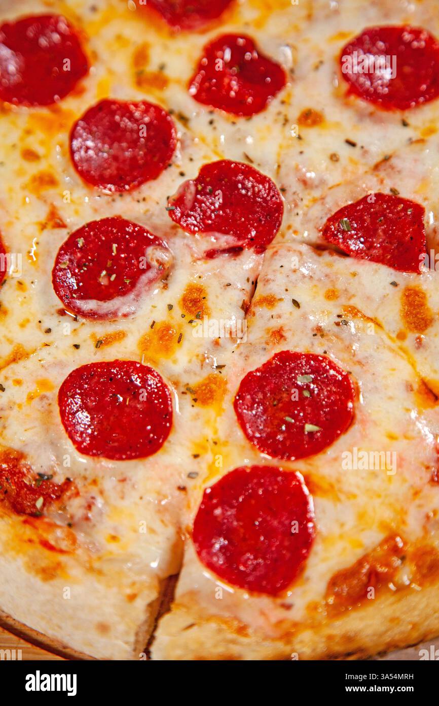 Napolean style wood fired flat bread pepperoni pizza on a white and ...