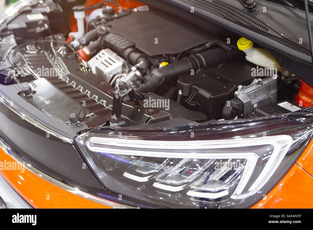 Open hood of a new car revealing engine in auto shop. Transport Stock ...