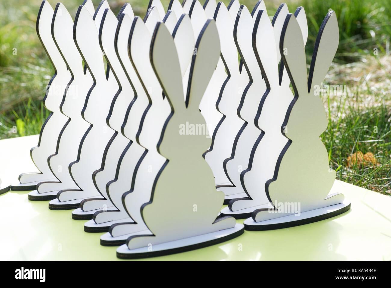 White Rabbit Army. Row of identical white wooden rabbit cutouts lines ...