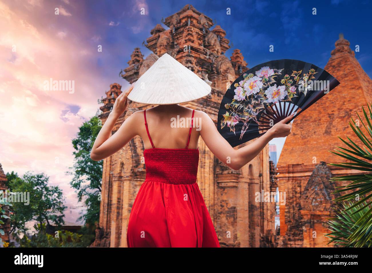 back of Asian girl tourist in Vietnamese hat Non La with fan on Cham ...
